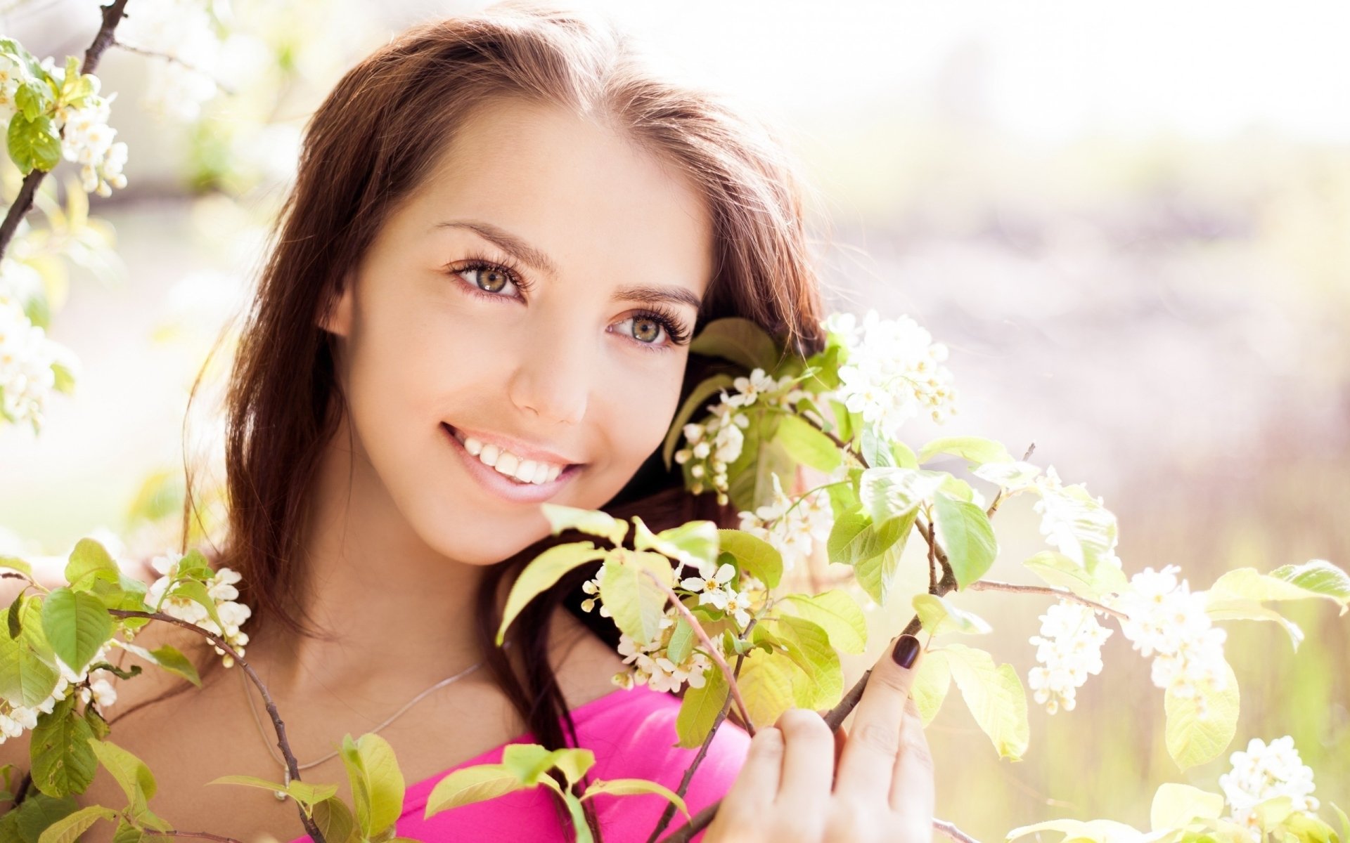 HD Wallpaper of a Smiling Woman Surrounded by Blossoms