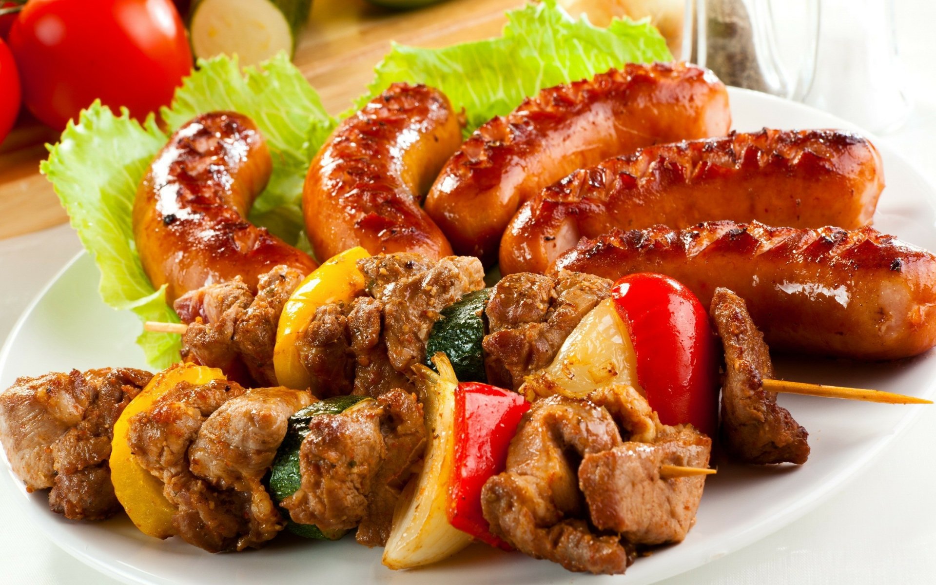 HD Barbecue Feast: Juicy Sausages & Skewers on a Fresh Bed of Greens